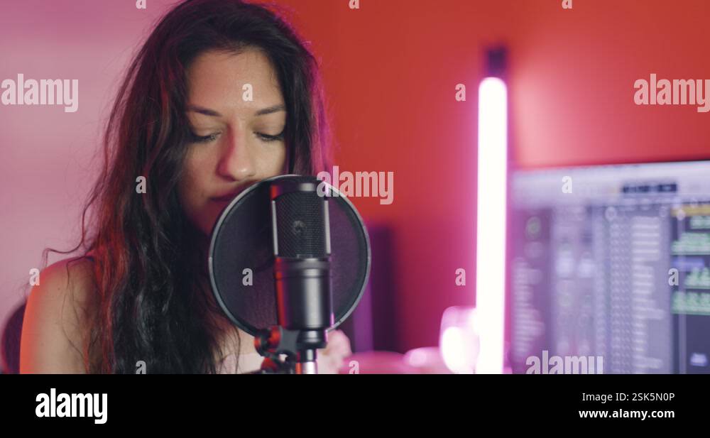 Girl singing on a professional studio microphone. Female music producer ...
