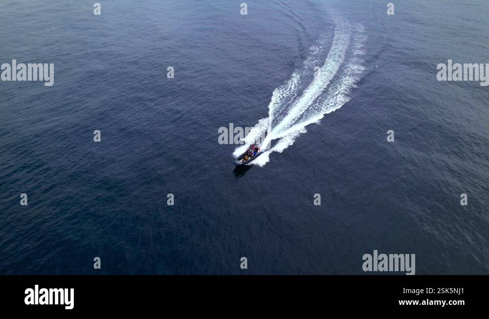 Aerial view of fast moving whale watching boat being steered in azure ...