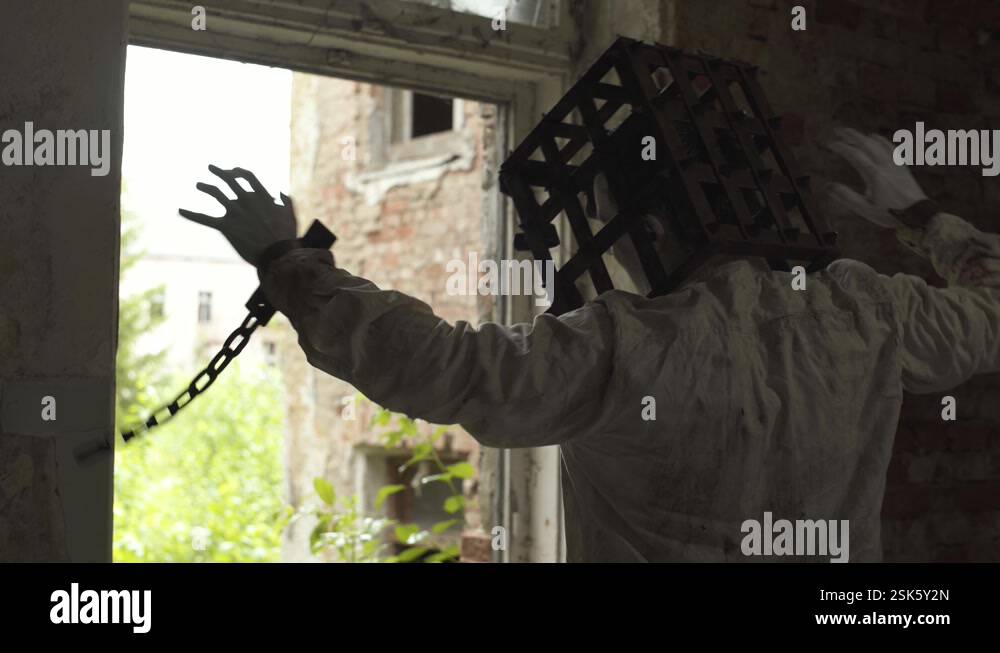Ghost of maniac with cage on his head squirming in corridor of ...