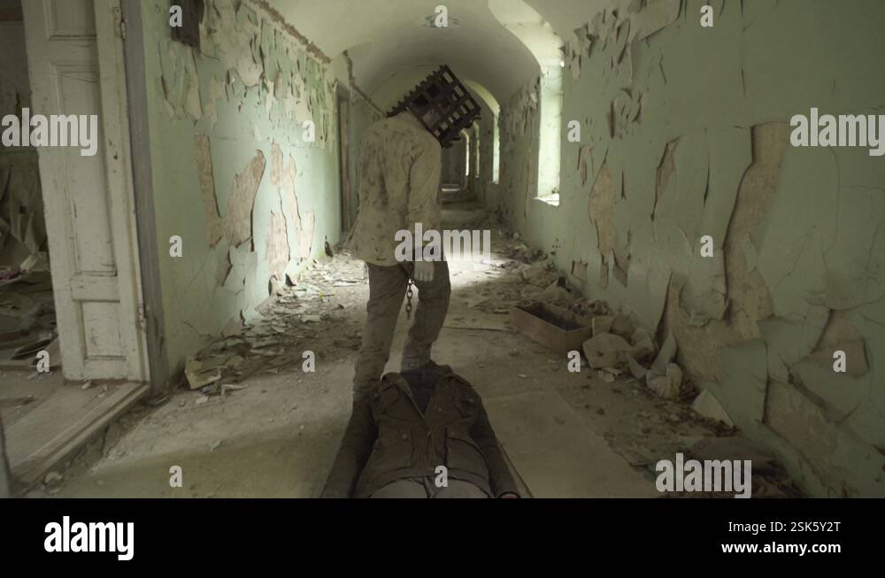 Ghost of maniac with cage on his head dragging dead body down corridor ...