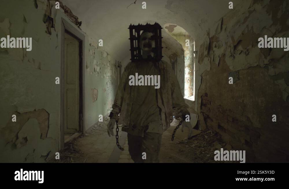 Ghost of maniac with cage on his head walking down corridor of ...