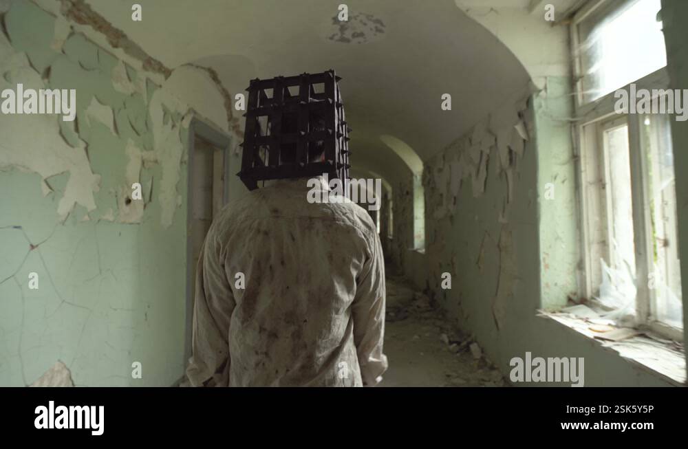 Ghost of maniac with cage on his head walking down corridor of ...