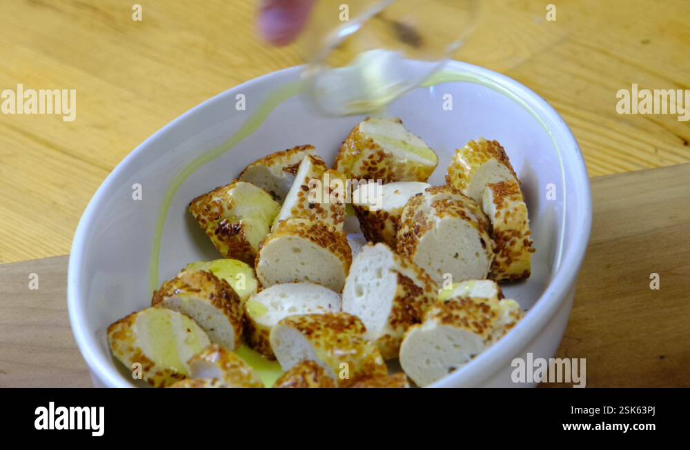 the cook is in the kitchen pouring olive oil on crispy bread Stock ...