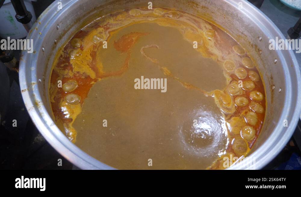 Pot of curry fishball soup boiling at street food night market cooking ...