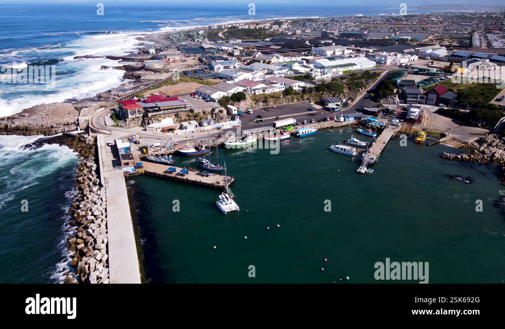 Drone pullback view over Hermanus New Harbour with some docked fishing ...