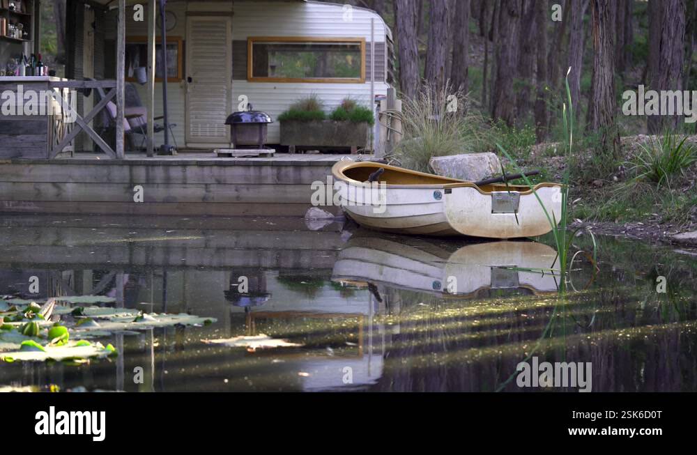Rowing boat on a lake docked at an isolated cabin in the forest (4K ...