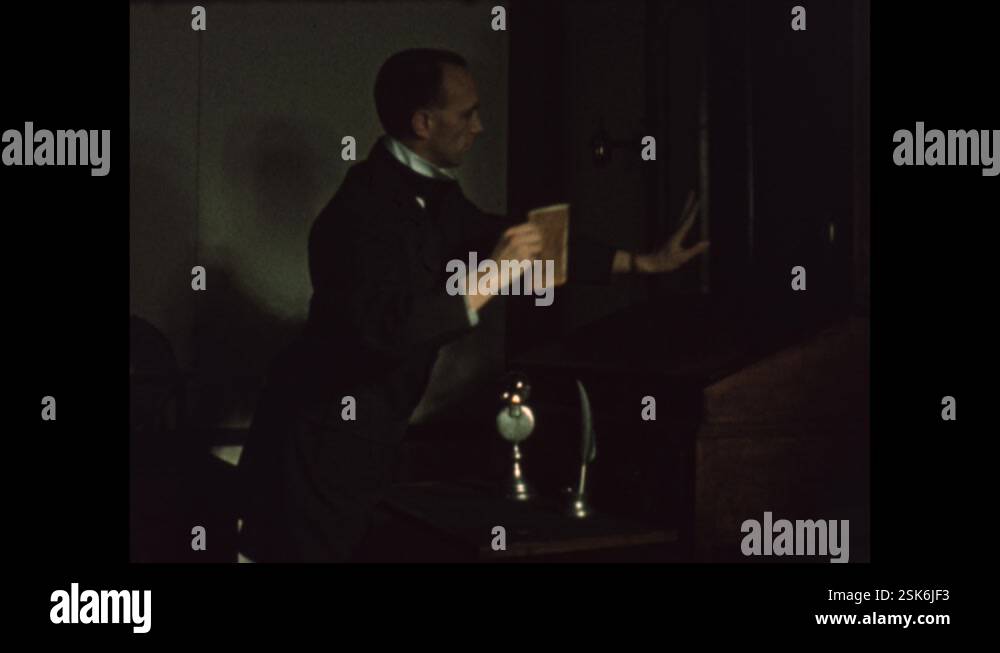 1960s: Man crosses room, takes diary off shelf, sits at desk and begins ...