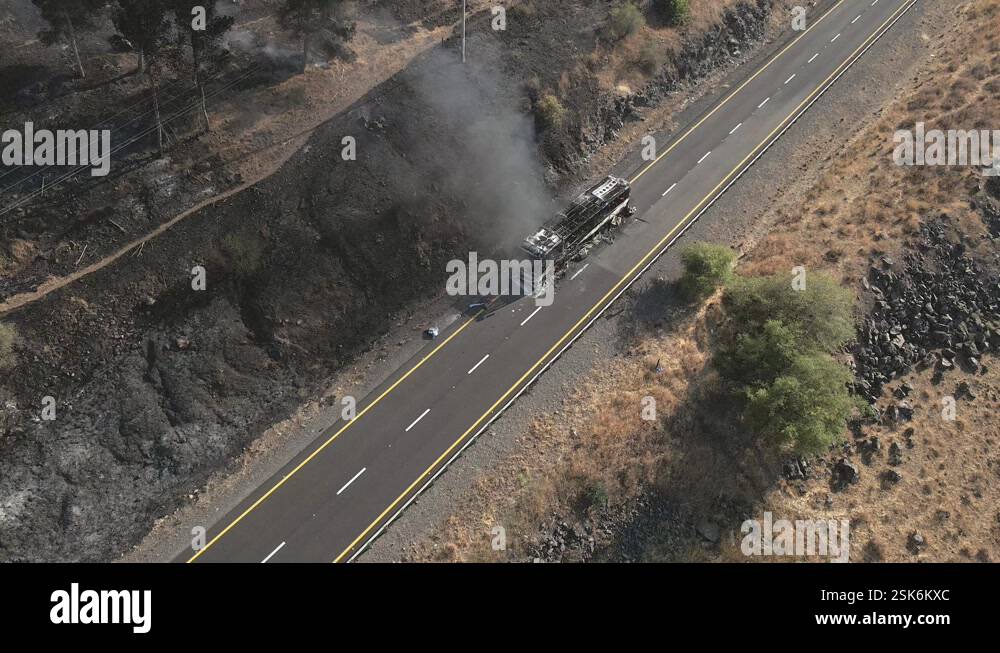 Top view, burning passenger bus on side of road and brush fire in Stock ...