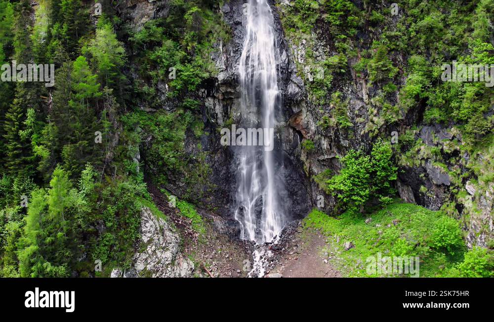 Panning shot left to right of a beautiful waterfall on a mountain side ...