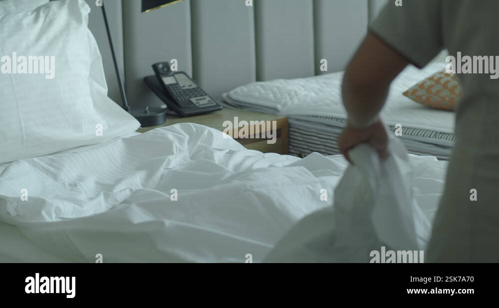 Employees, two maids of the hotel, professionally make the bed in the ...