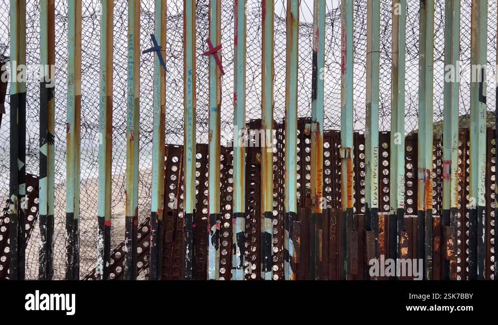 Pan along the border wall that separates Mexico and the United States ...
