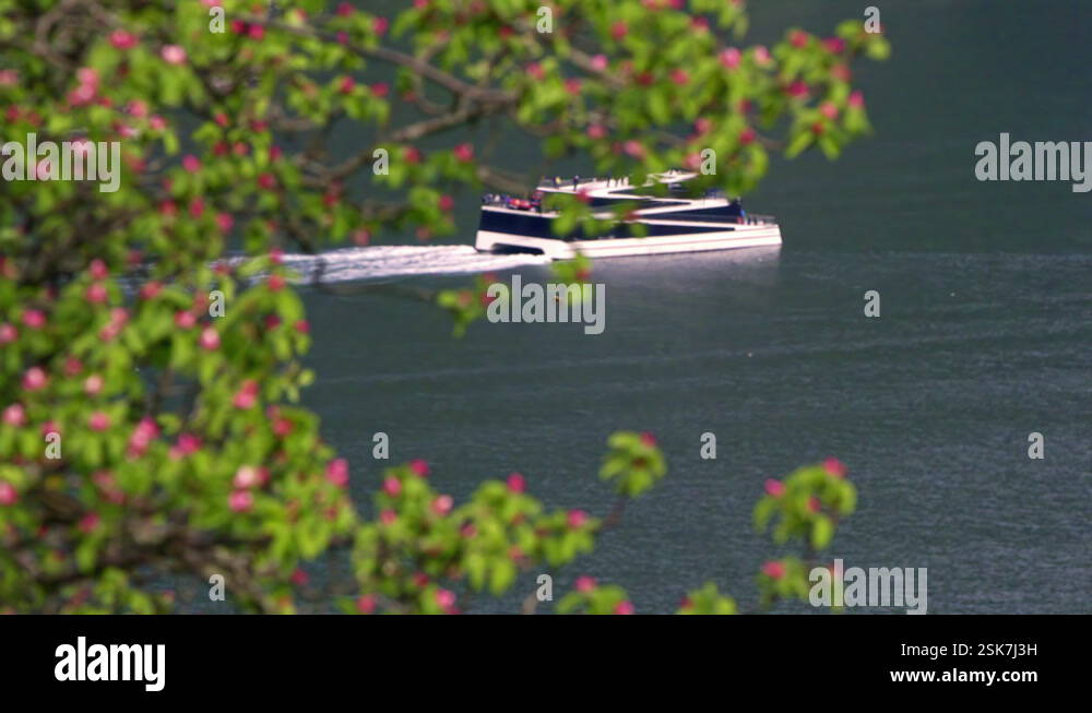 Slow motion view of a yacht cruising across a body of water from behind ...