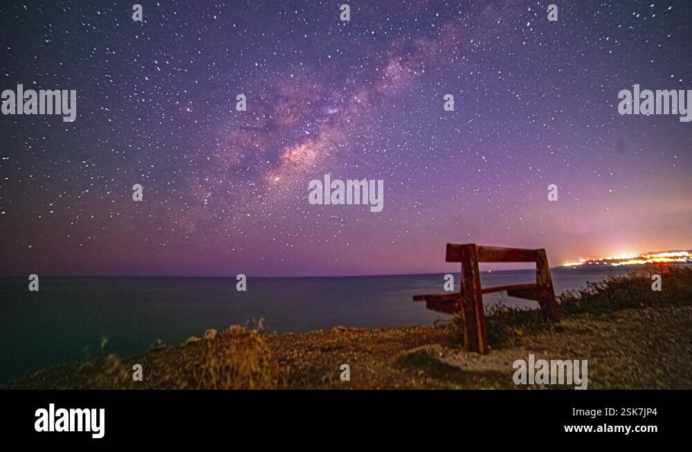 Timelapse of the milky way and moving stars. In the foreground a wooden ...