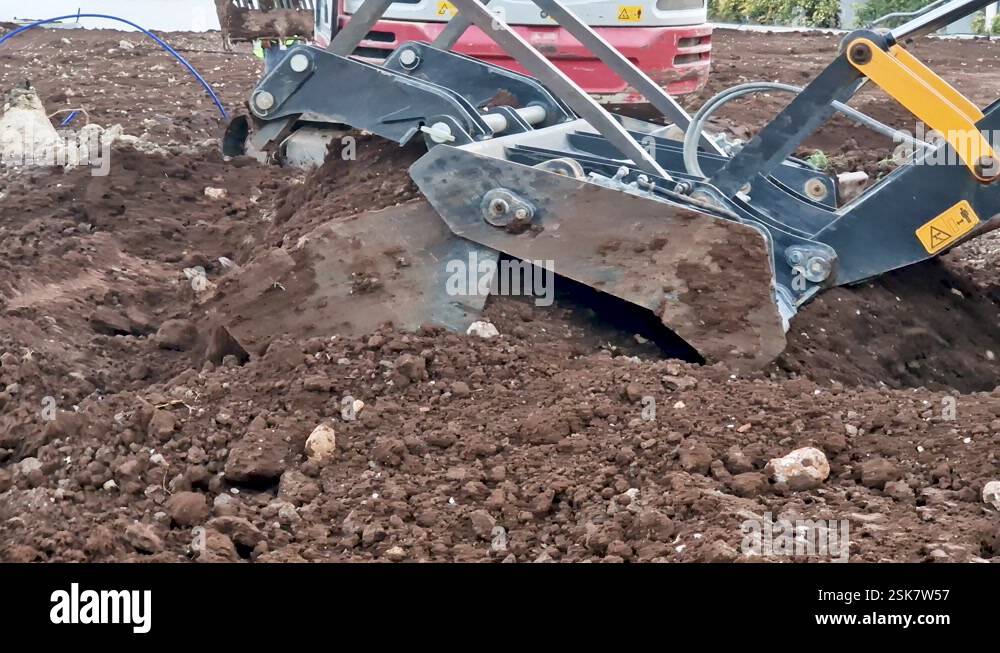 Close up of industrial excavator loading soil material on a highway ...