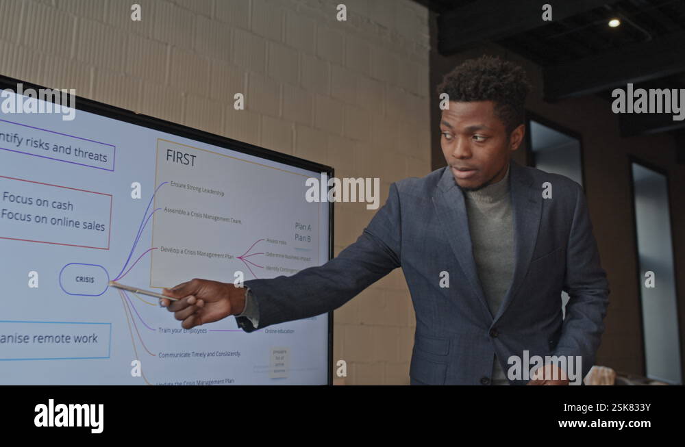 Black Male Business Analyst Demonstrating Strategy Chart in Office ...