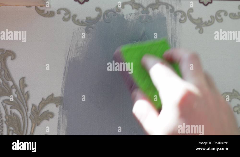 Paint test with a sponge on the wall with wallpaper before painting the ...