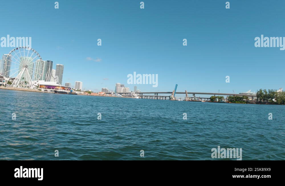 boat perspective of Miami passing by a Ferris wheel on Biscayne Bay ...