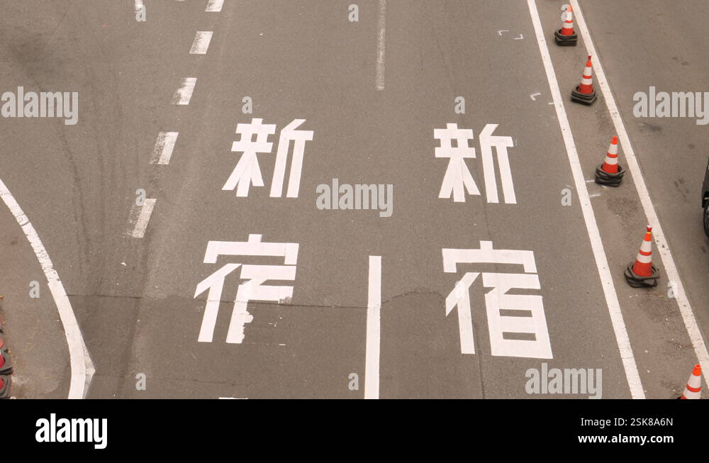 Japanese directions painted on the road and traffic passing underneath ...