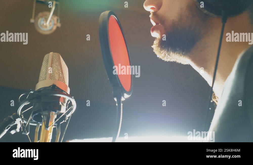Male singer singing in sound studio. Man recording new song. Guy with ...