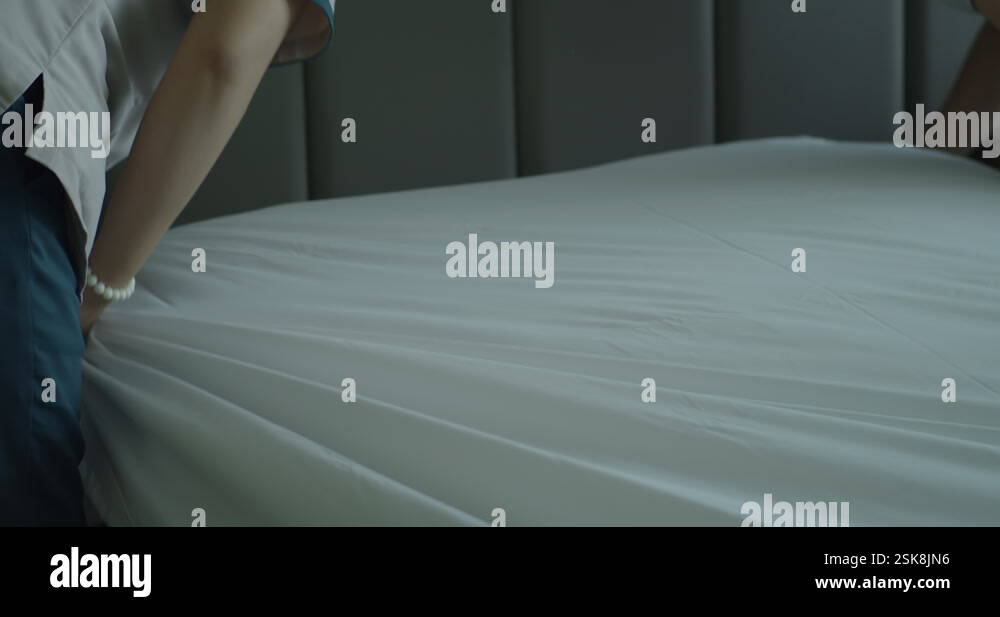 Employees, two maids of the hotel, professionally make the bed in the ...