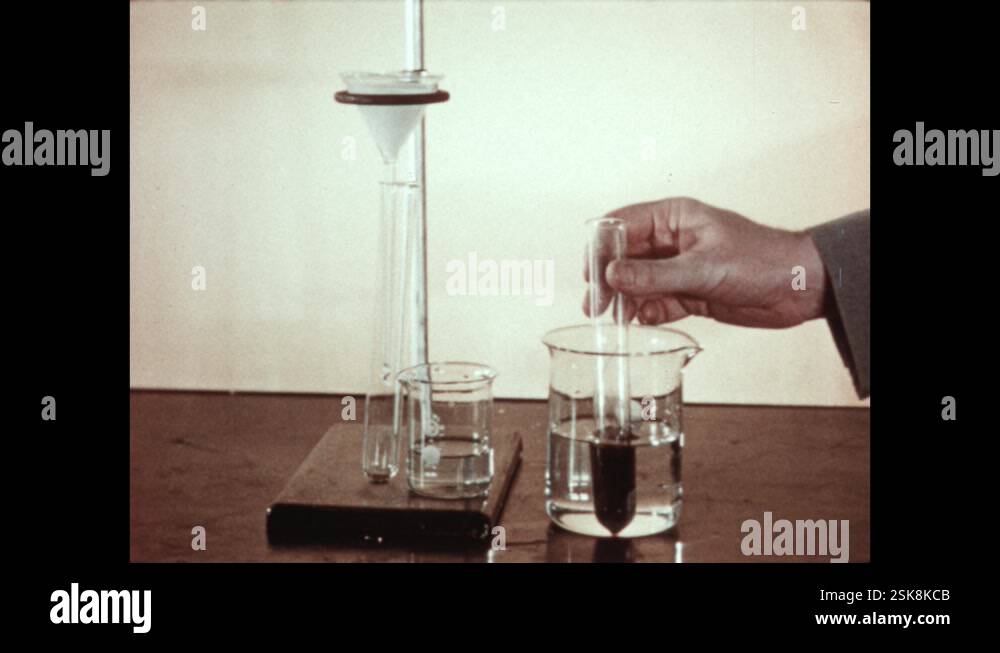 1960s: A test tube with an opaque liquid rests in a beaker of water. A ...