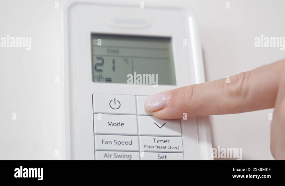 The camera focuses on the air conditioner remote control on the white ...