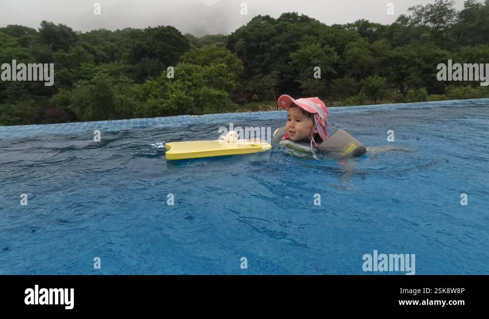 3 Year Old Child Girl Lean Swimming in Outdoor Pool on Rainy Day Stock ...