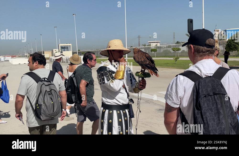 Tourists curiously watch an eagle handler showcase the eagle on an ...