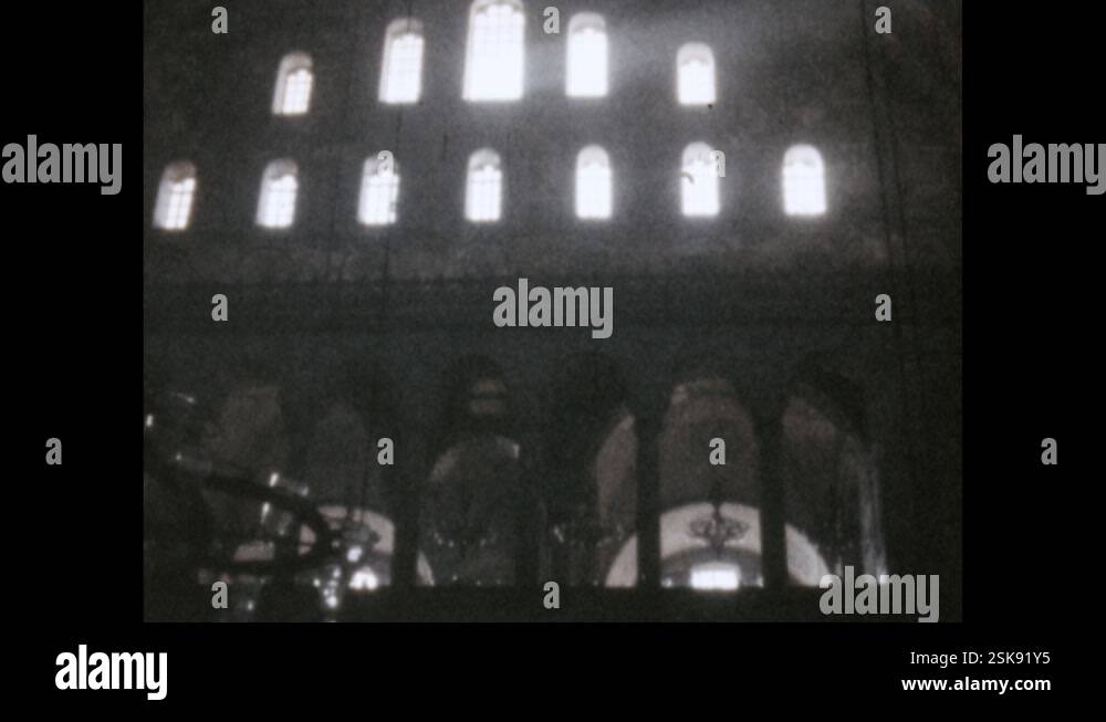1960s: Inside of building, tall columns, large windows and several ...