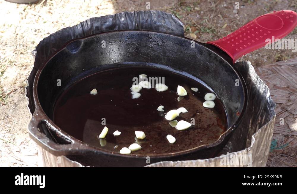 Adding garlic to a hot pan outside Stock Video Footage - Alamy