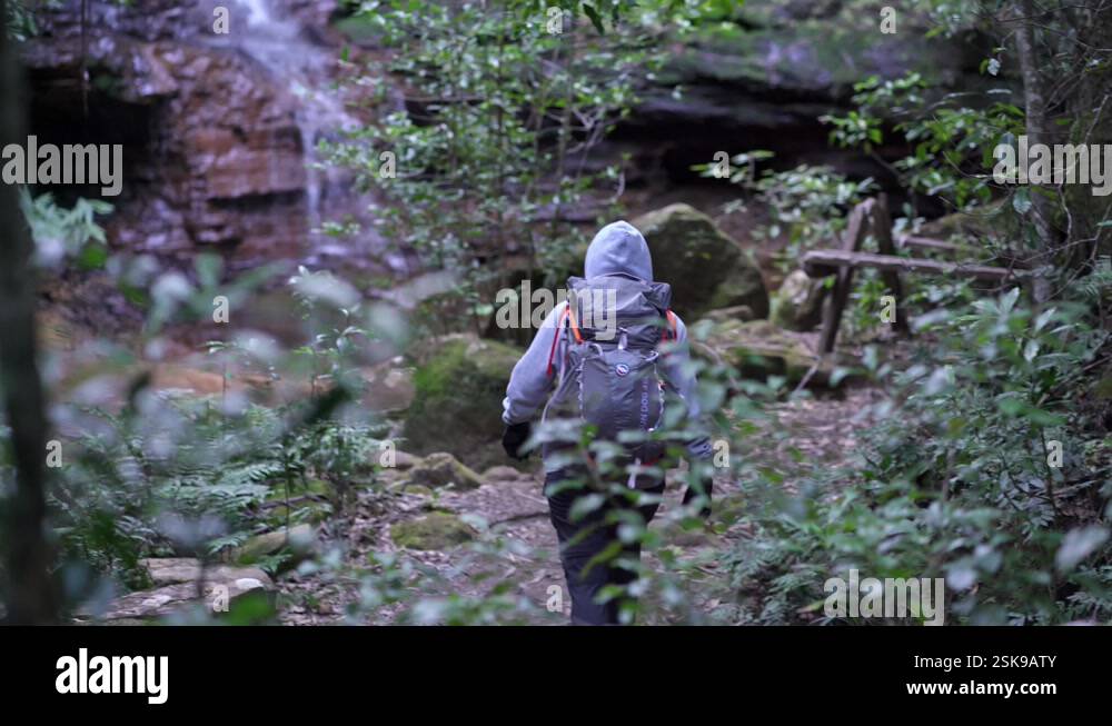 Indigenous Australian woman backpacking to a beautiful remote waterfall ...