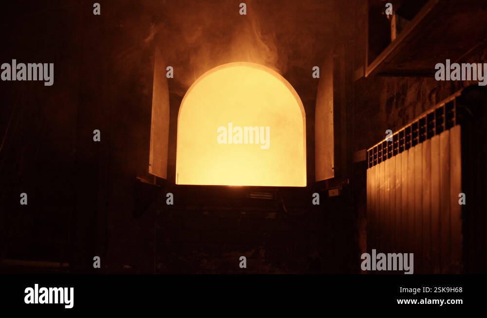 Frightening furnace with burning flame as hell gate in dark crematorium ...