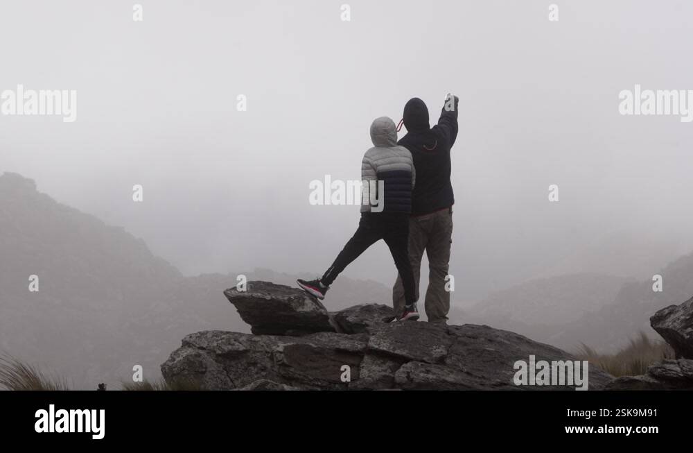Father and son contemplating the landscape on an overcast day on top of ...