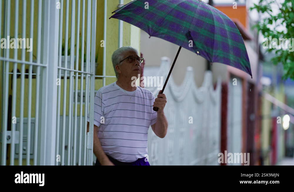 Senior Man Returning Home in Rain, Unfurls Umbrella and Secures Gate ...