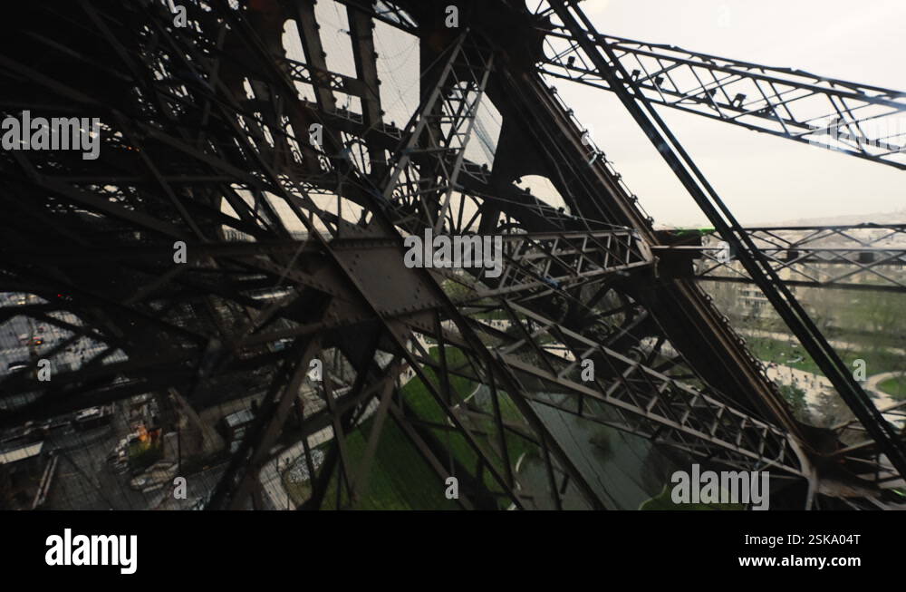 rising elevator shot of the architectural framework of the Eiffel Tower ...