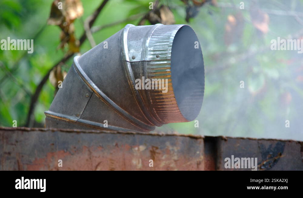 Extreme close up of smoke rising from metal duct air pipe connected ...