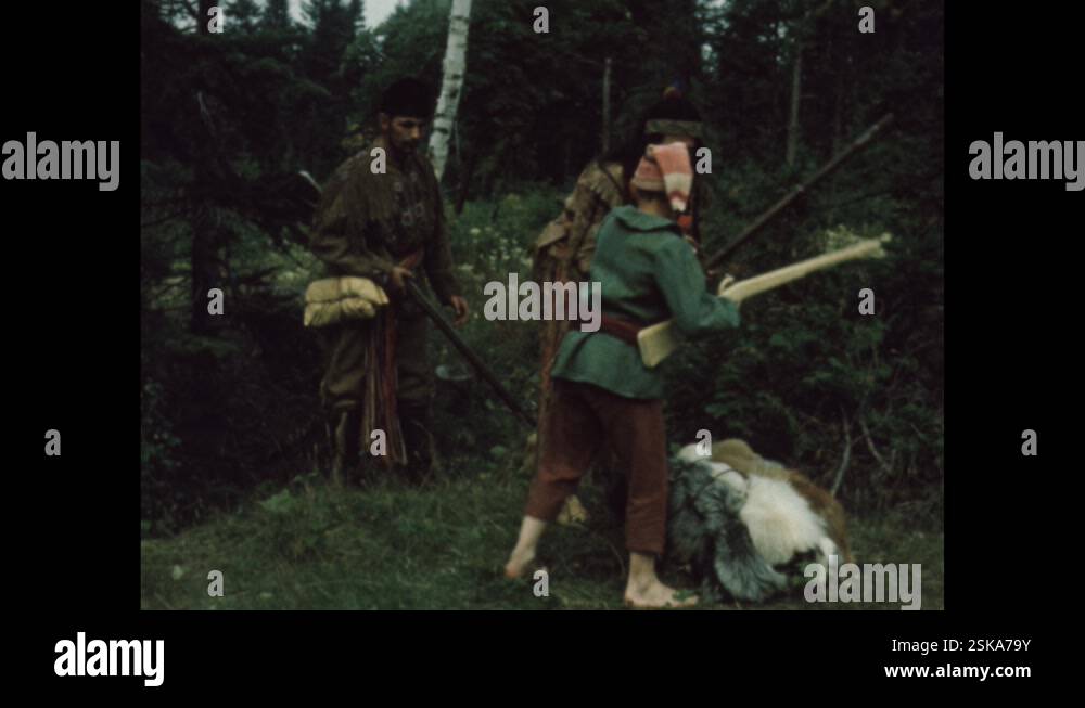 1960s: Two hunters with furs and rifles, talk to boy in forest. Boy ...