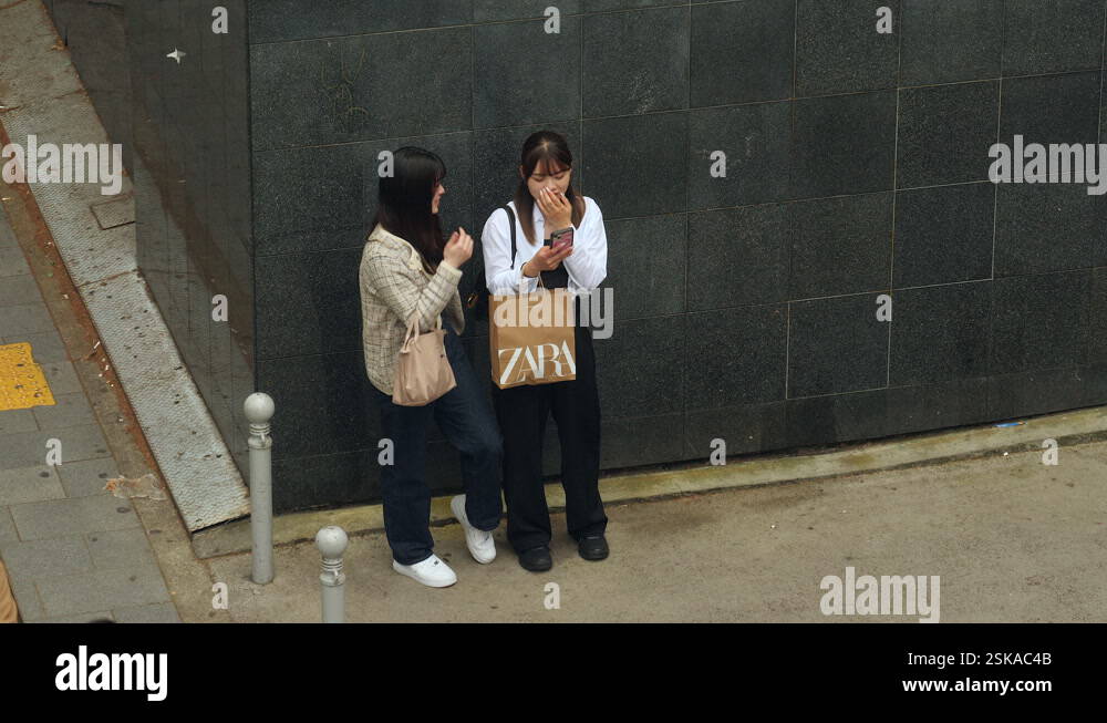 Two young Japanese women socializing on street corner. Top view. Tokyo ...