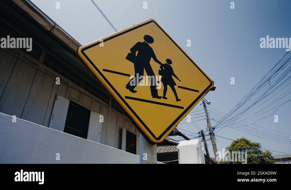 Caution school zone yellow road sign with symbol of parent and child ...