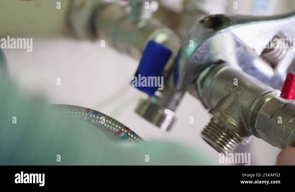 tightening the threaded connection of plumbing pipes with a wrench ...
