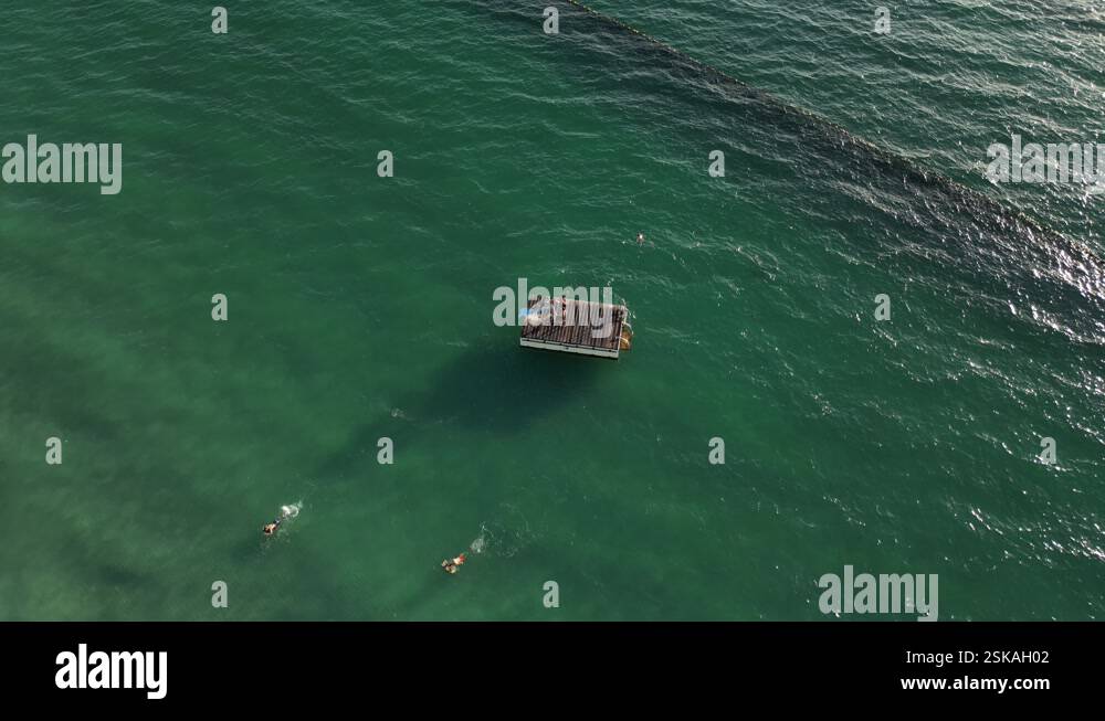 People jumping from a floating platform at Coogee Beach in Perth Stock ...