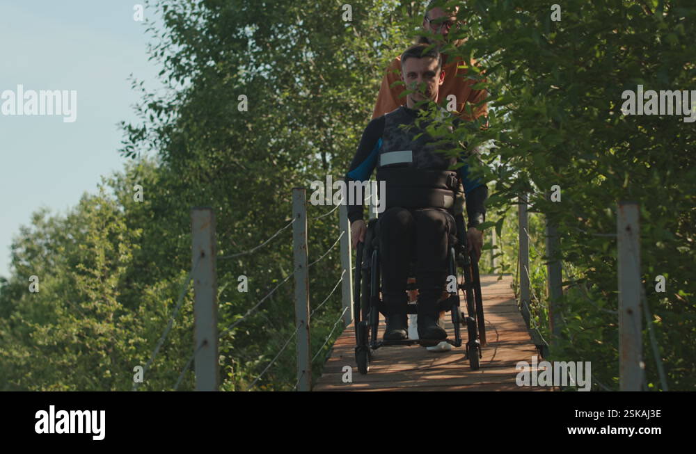Man Moving in Wheelchair along Wooden Bridge at Riverside Stock Video ...