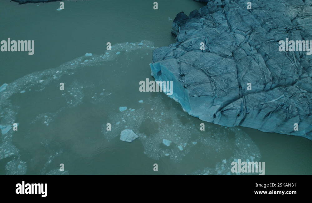 Icebergs falling in the water while a Glacier is melting due to climate ...