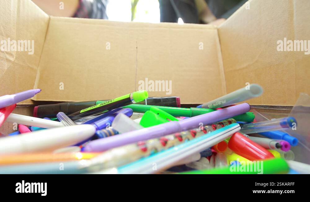 Hands of women put old used felt-tip pens in a waste disposal box for ...