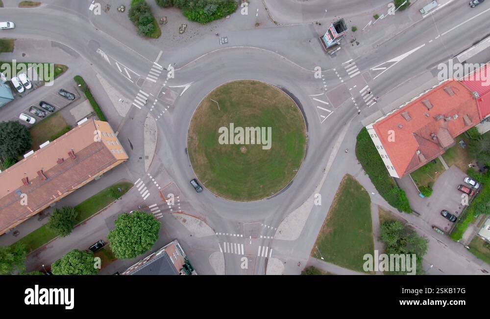 Top down aerial view of a roundabout. Rising orbiting shot. Cars and ...