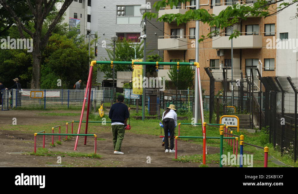 Parents pushing children on swing at playground. Tokyo, Japan Stock ...