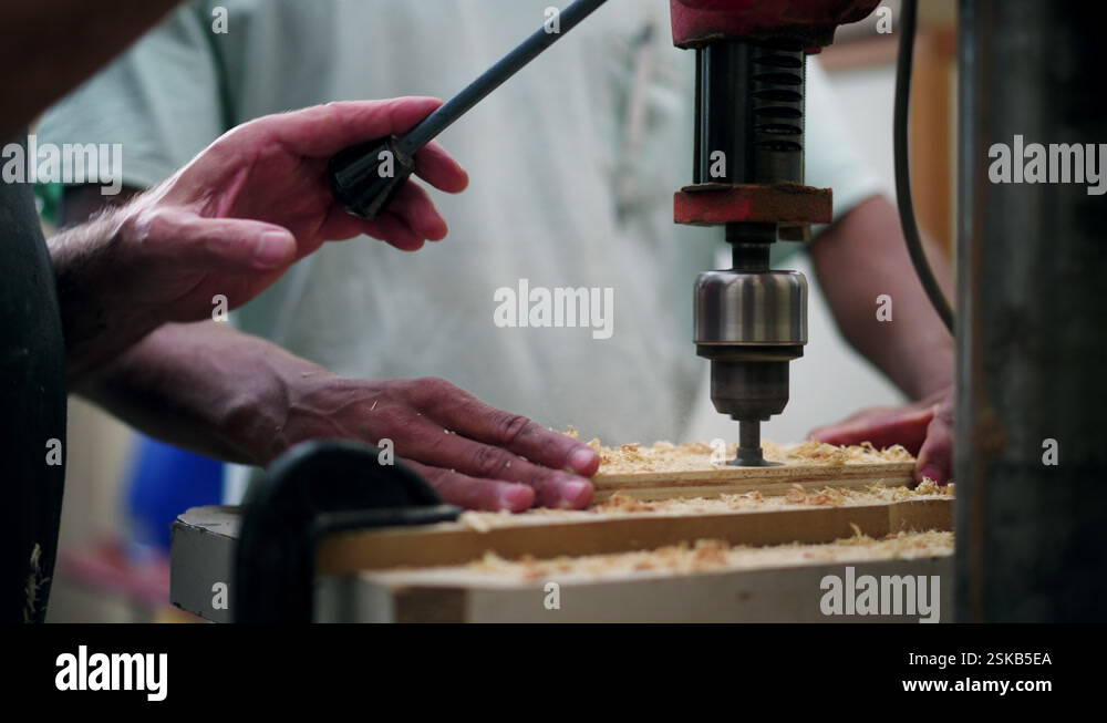 One young black Brazilian worker using drilling machine to male hole on ...