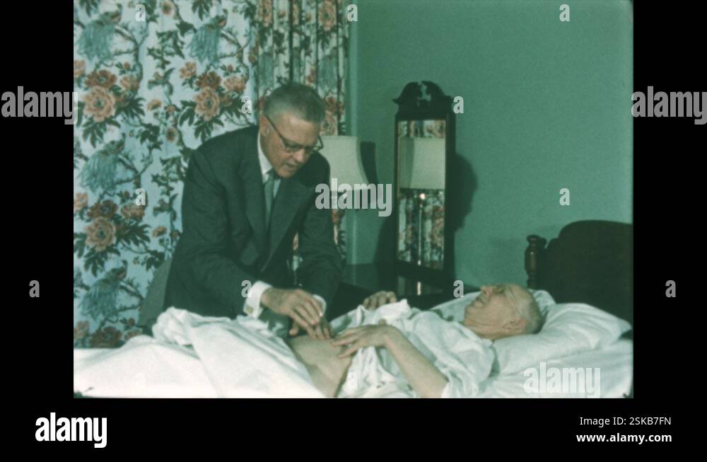 1960s: Doctor examines elderly man's abdomen in hospital bed Stock ...