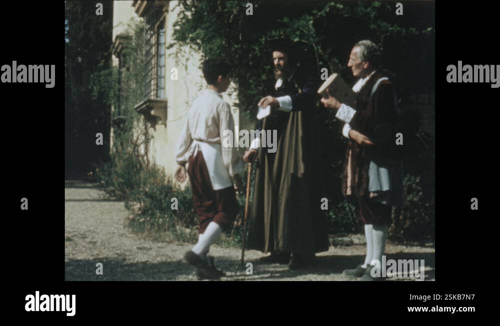 1960s: 2 men in Renaissance robes and cape with boy, man with cane ...