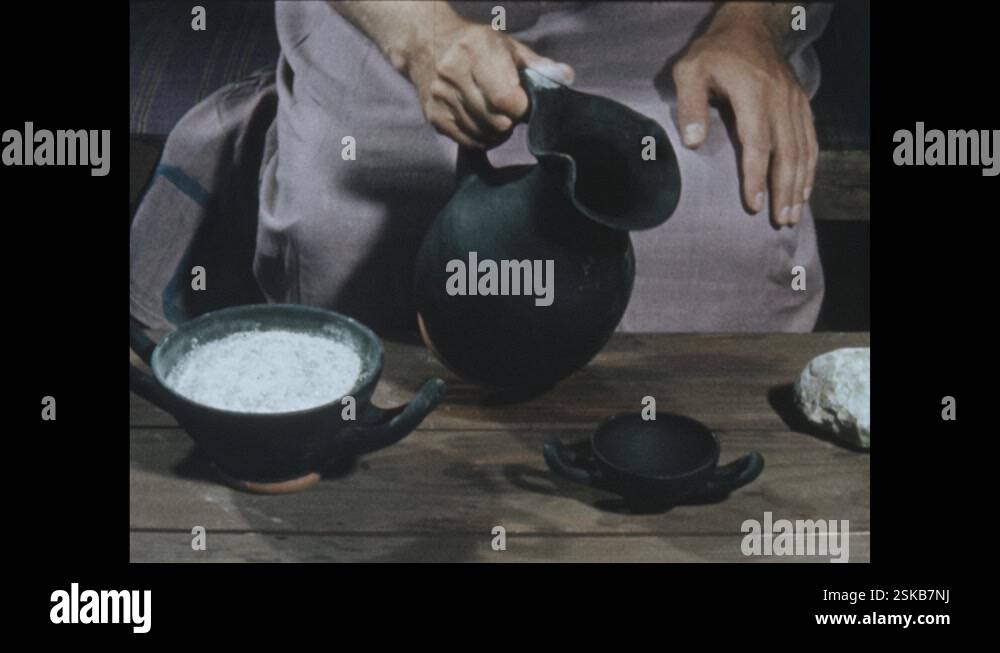 1960s: hand picks up white powder from pottery bowl, rubs it in fingers ...